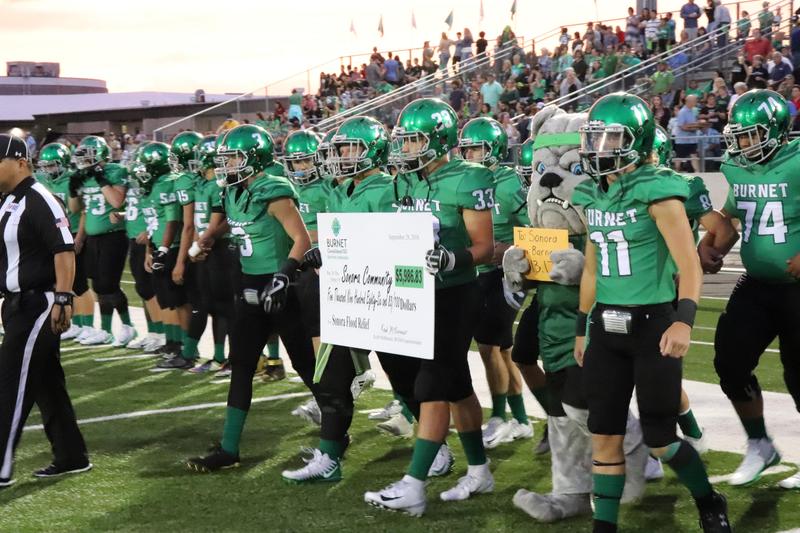 Football Captains Present Flood Relief Check | Burnet Consolidated ISD